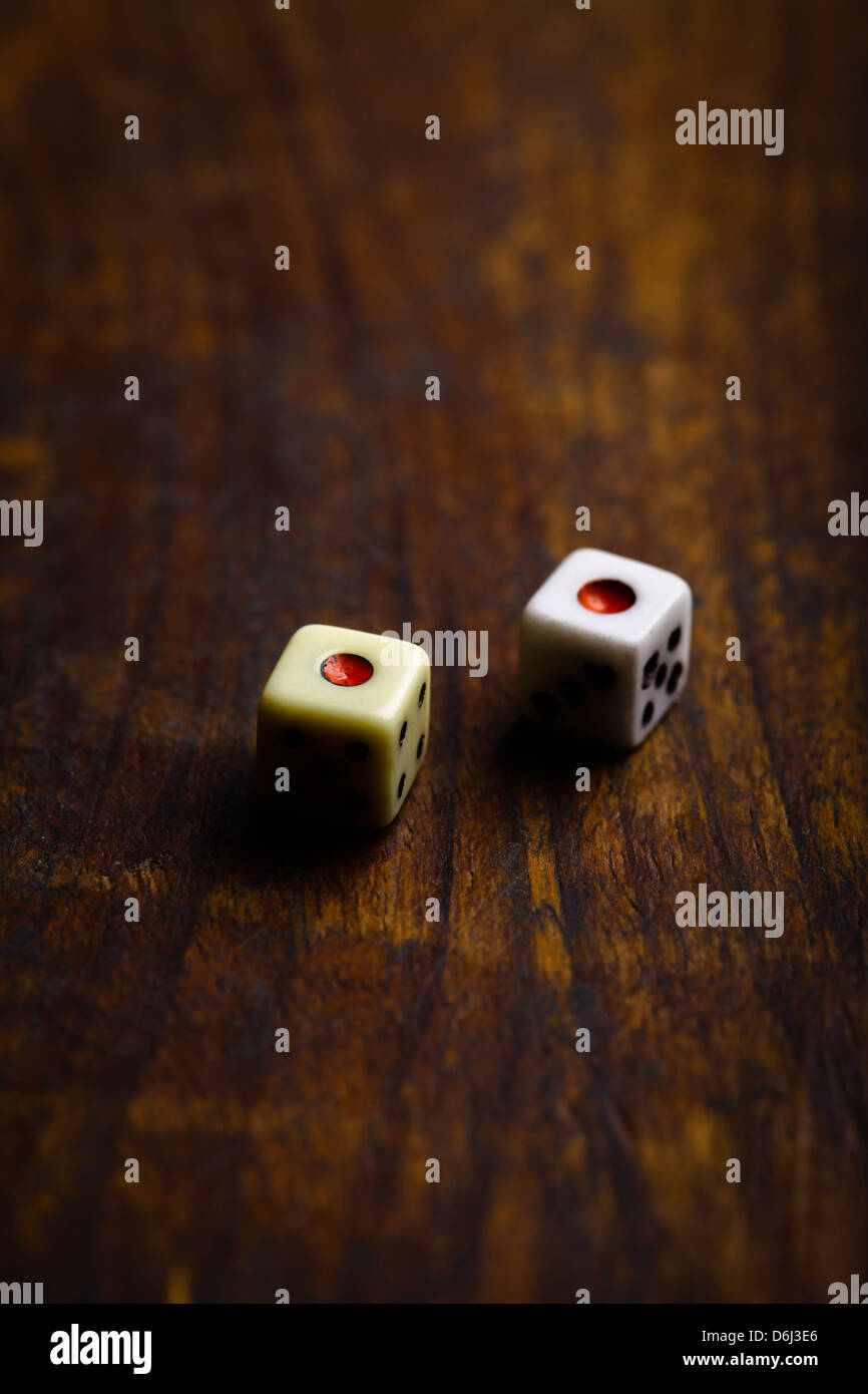 Two dice displaying one on a vintage wood plank Stock Photo - Alamy