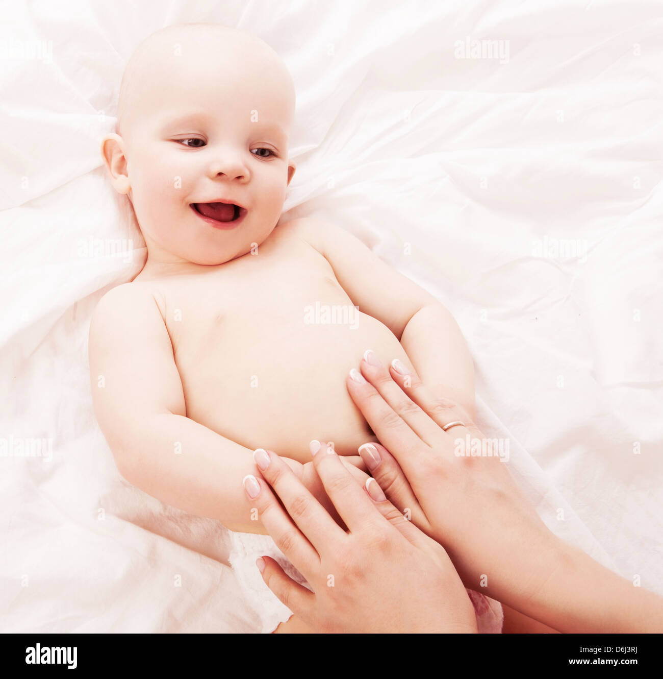 happy baby getting a body massage in bed at home Stock Photo - Alamy