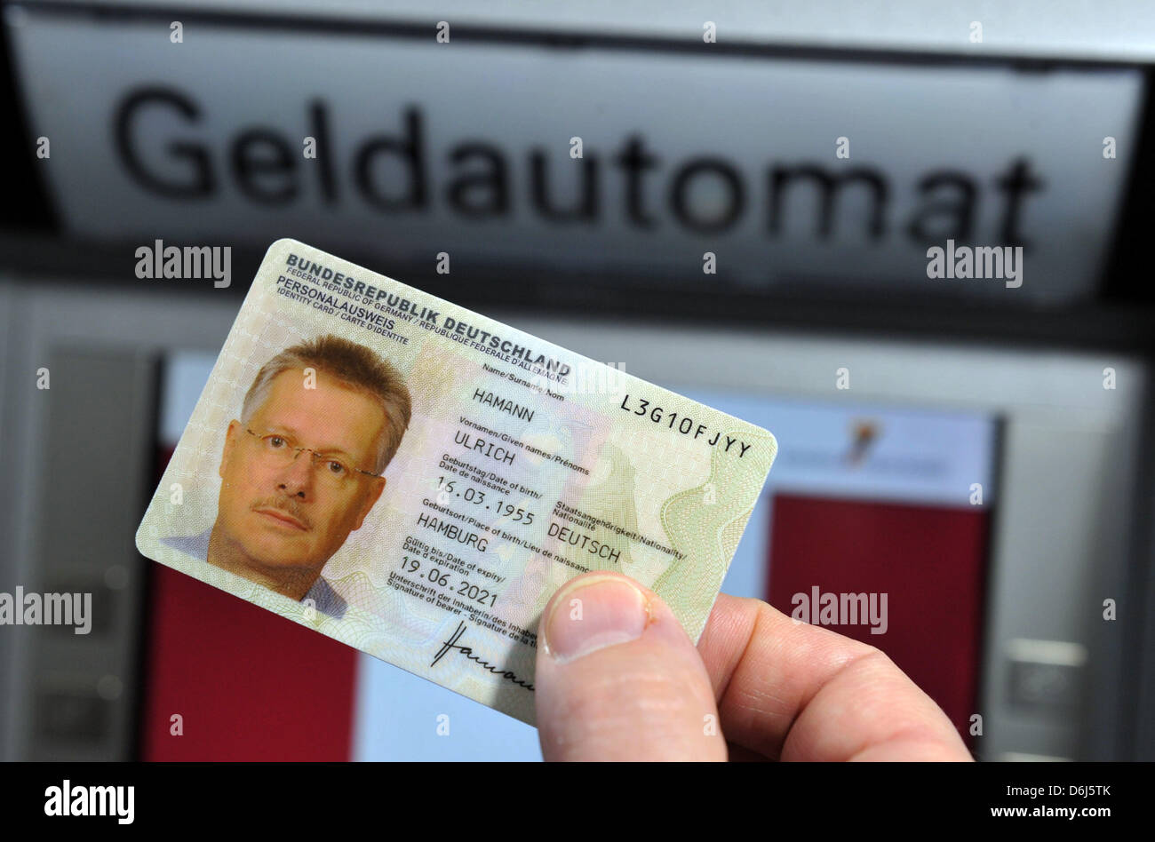 A man uses his new identity card at an automated teller machine at the ...