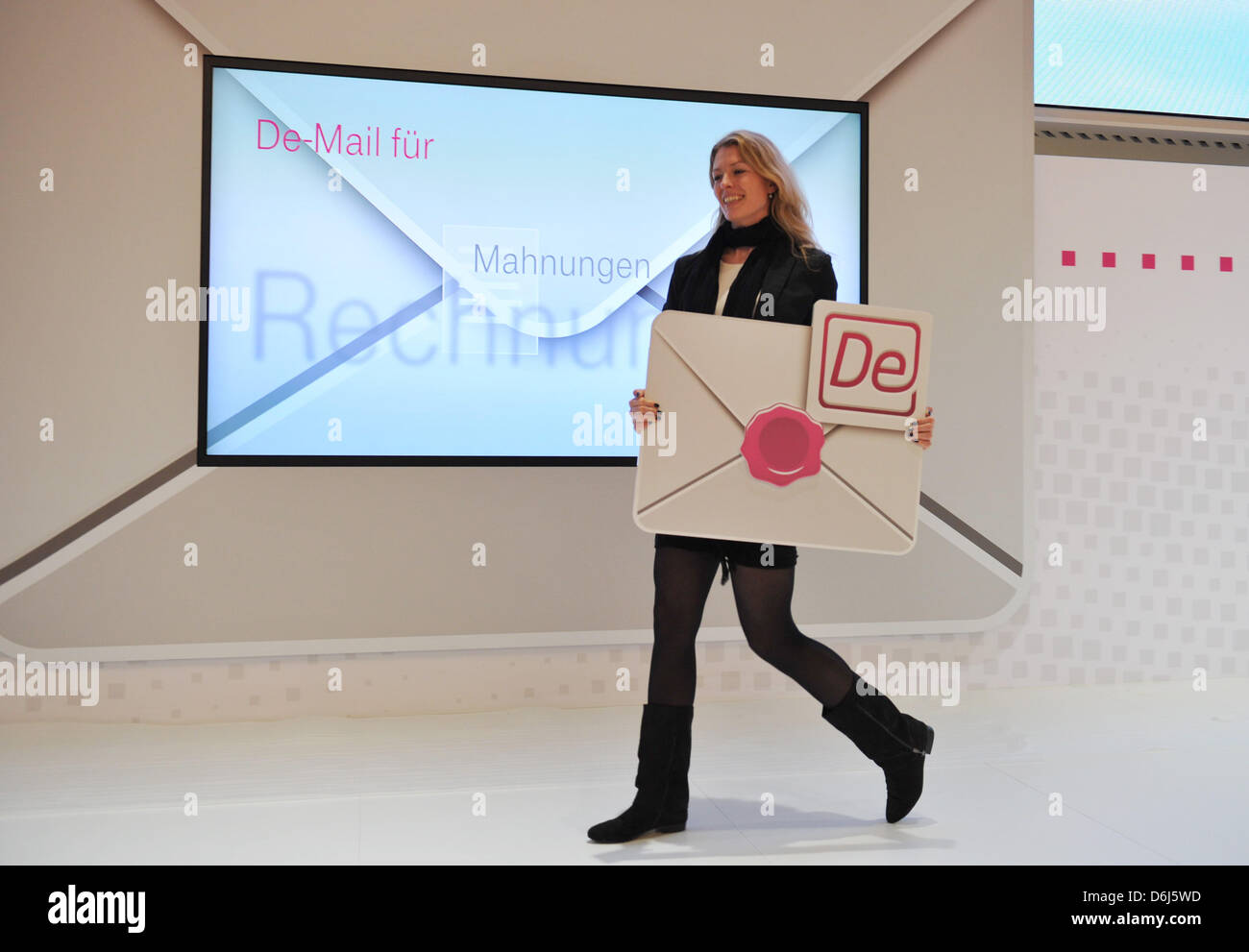 A Deutsche Telekom employee holds a poster with the logo of the company ...