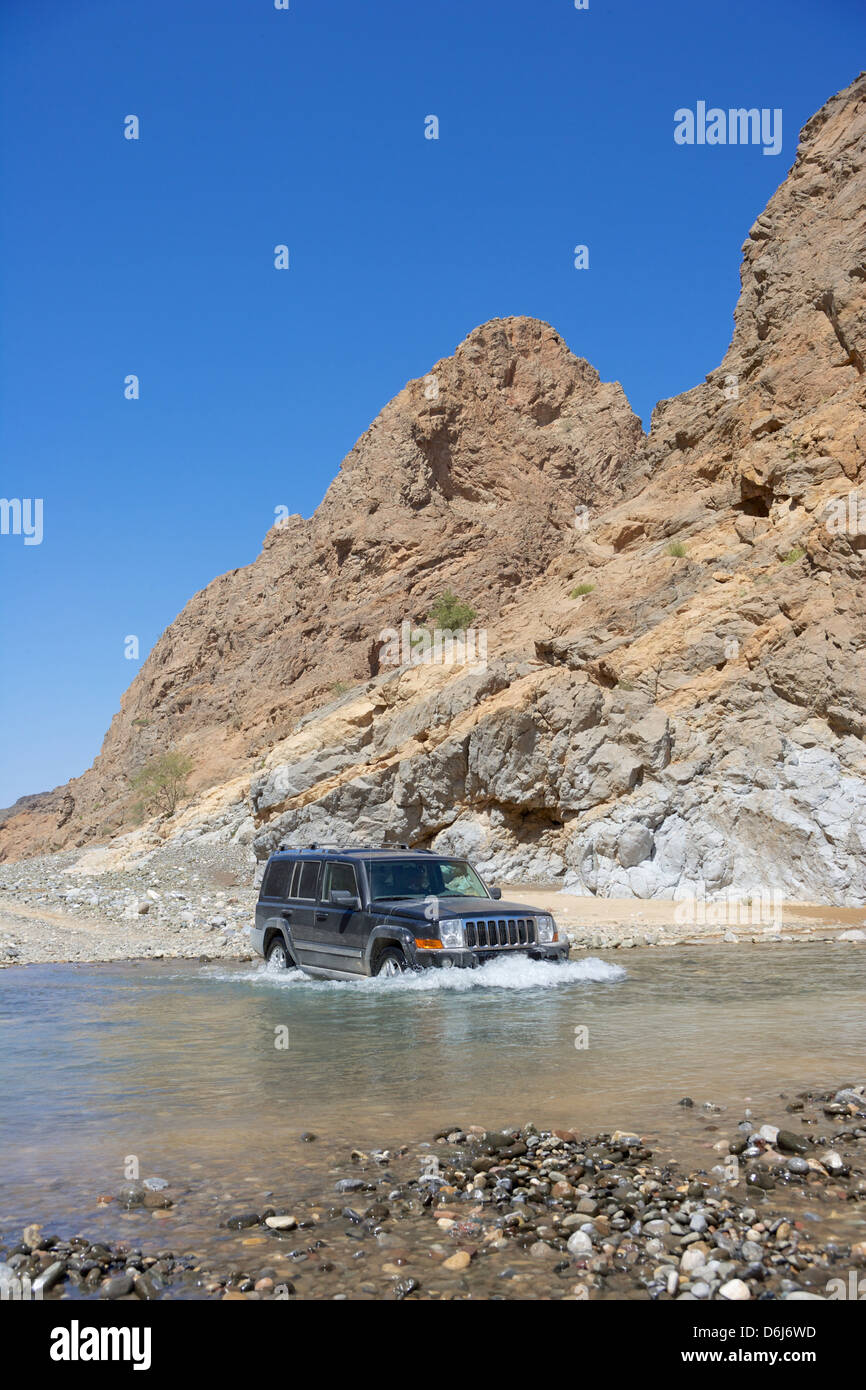 A 4x4 vehicle crossing a river in a wadi in Oman Stock Photo - Alamy
