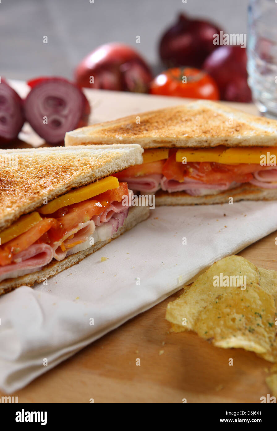 Closeup of toasted ham cheese and tomato sandwich on a white napkin on ...