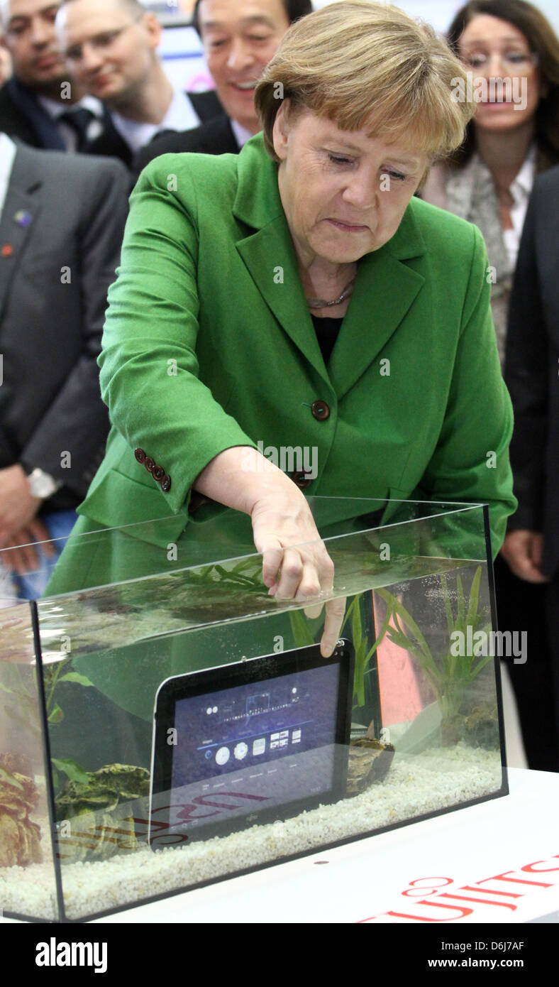 German Chancellor Angela Merkel submerges a Fujitsu tablet PC into an ...