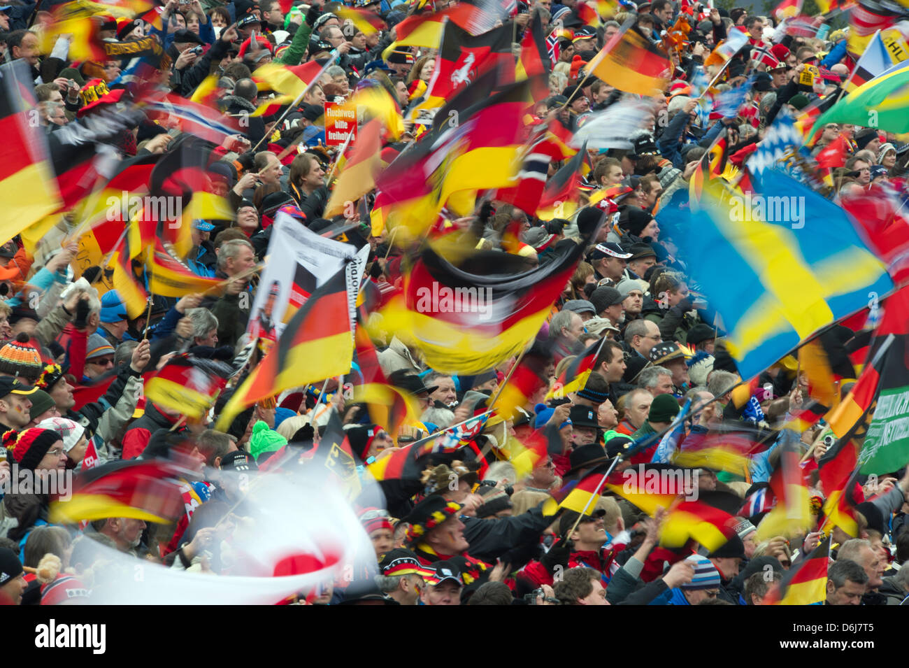Biathlon fans wave flags during the men's single 20 km at the 2012 ...
