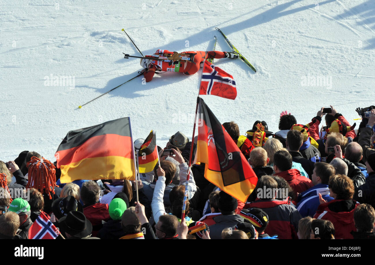 Norwegian biathlete Tora Berger lies in the finish area during the ...