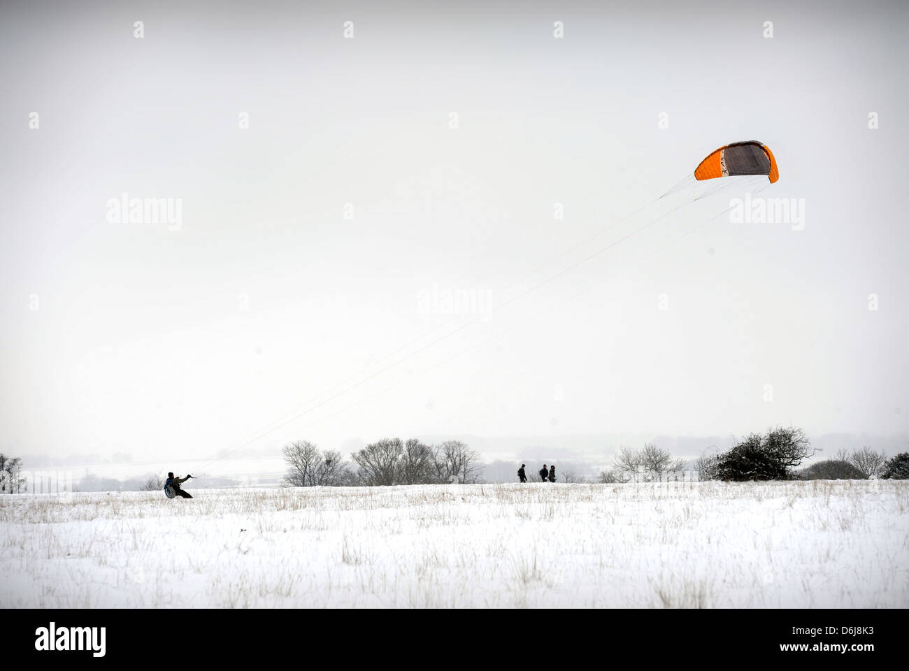 A man 'kitesurfing' or 'snowkiting' in the snow on Minchinhampton ...