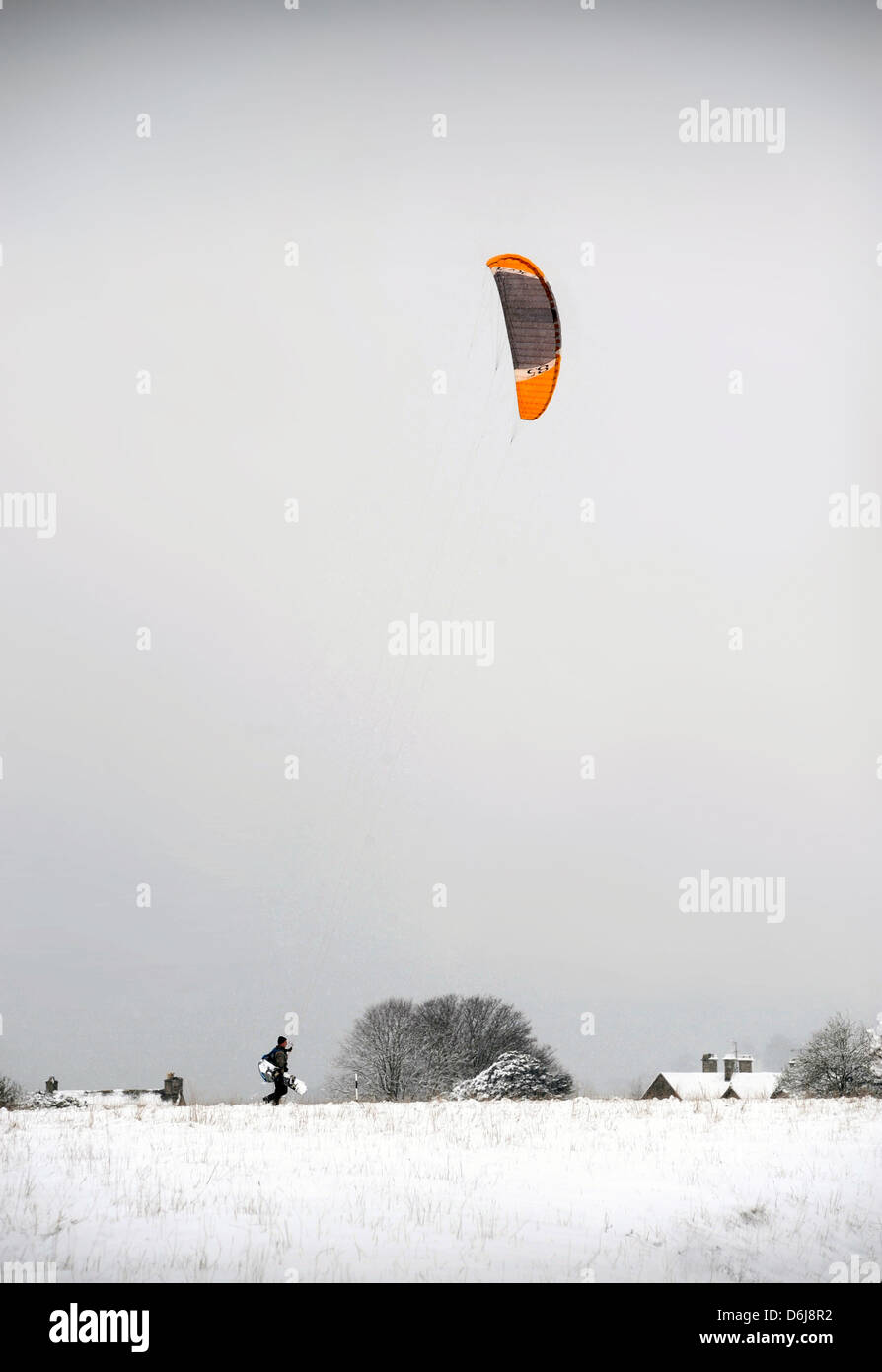 A man 'kitesurfing' or 'snowkiting' in the snow on Minchinhampton ...