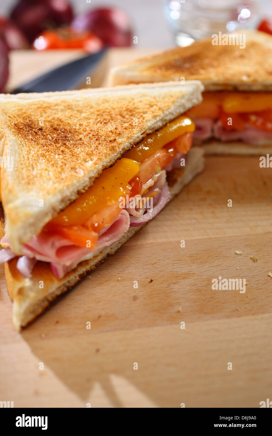 Toasted ham cheese and tomato sandwich on a wooden breadboard Stock ...
