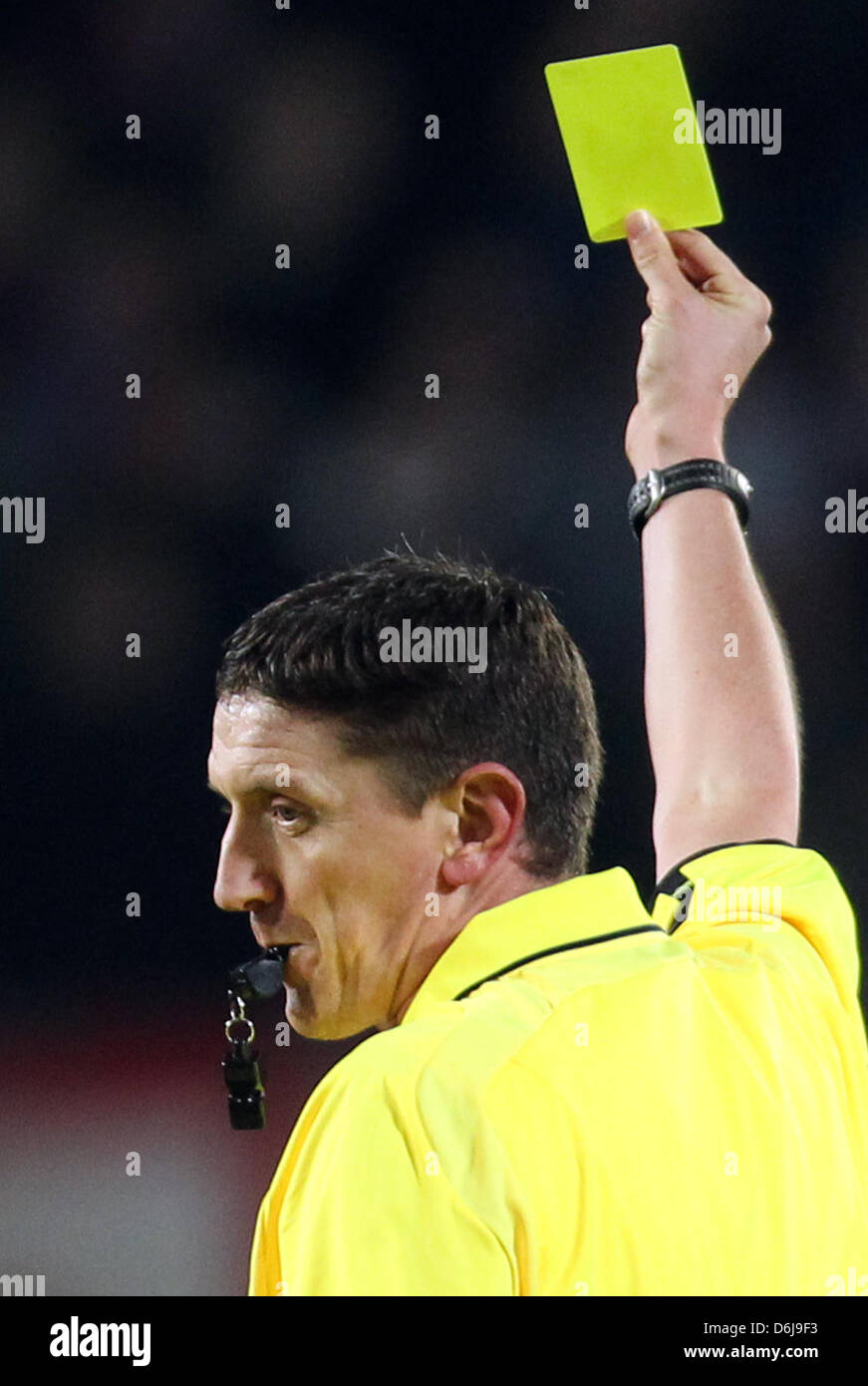 Referee Craig Thomson shows a yellow card during the Europa League ...