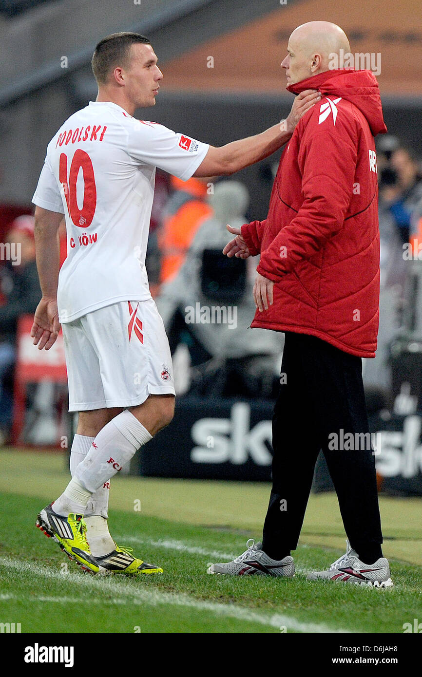 Cologne's player Lukas Podolski (l) touches the throat of Cologne's ...