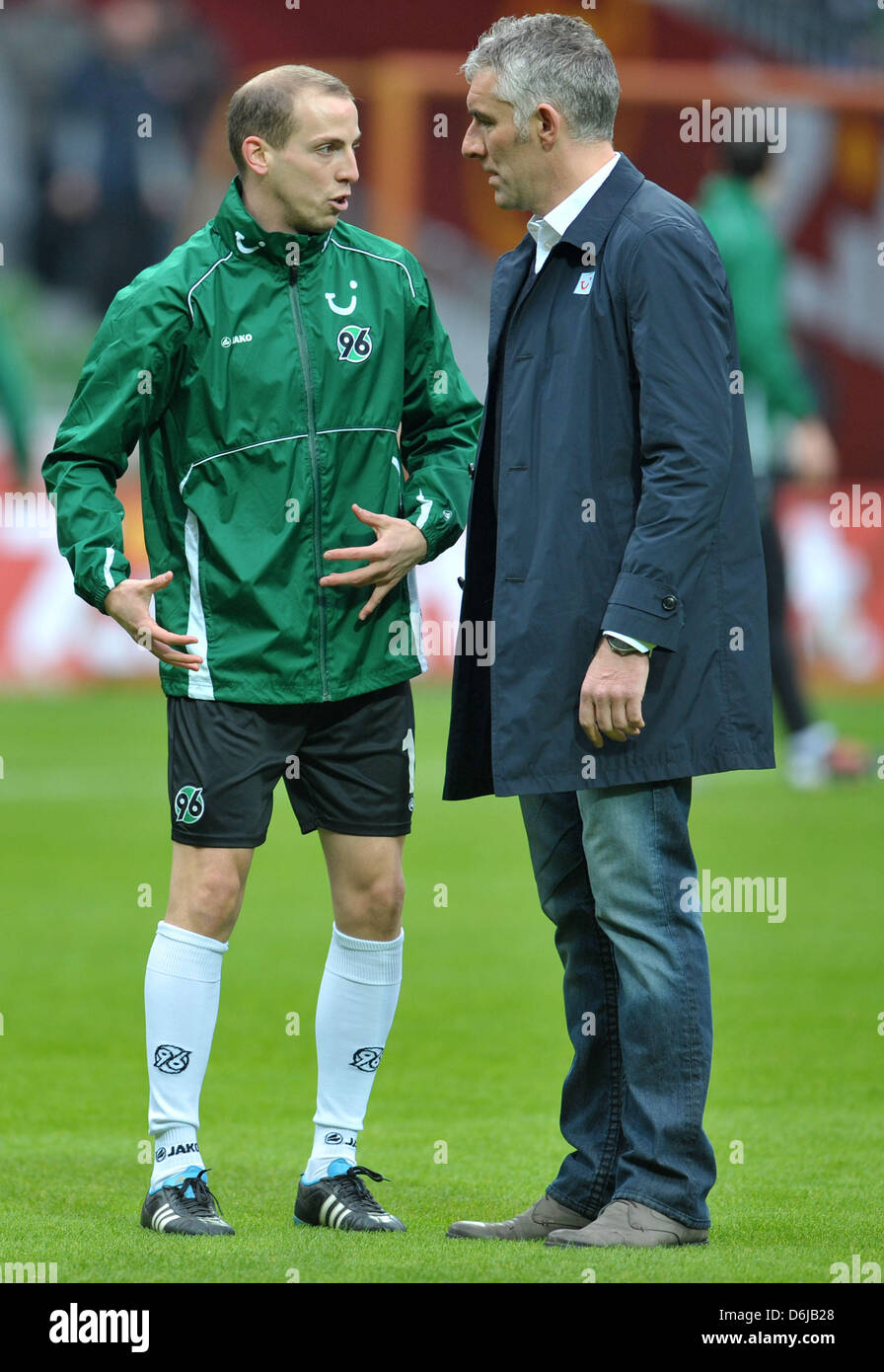 Hanover's head coach Mirko Slomka talks to player Jan Schlaudraff prior ...