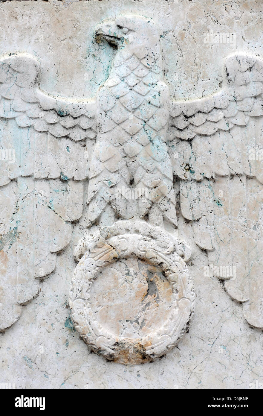 An imperial eagle holding a wreath (with a removed swastika) is carved ...
