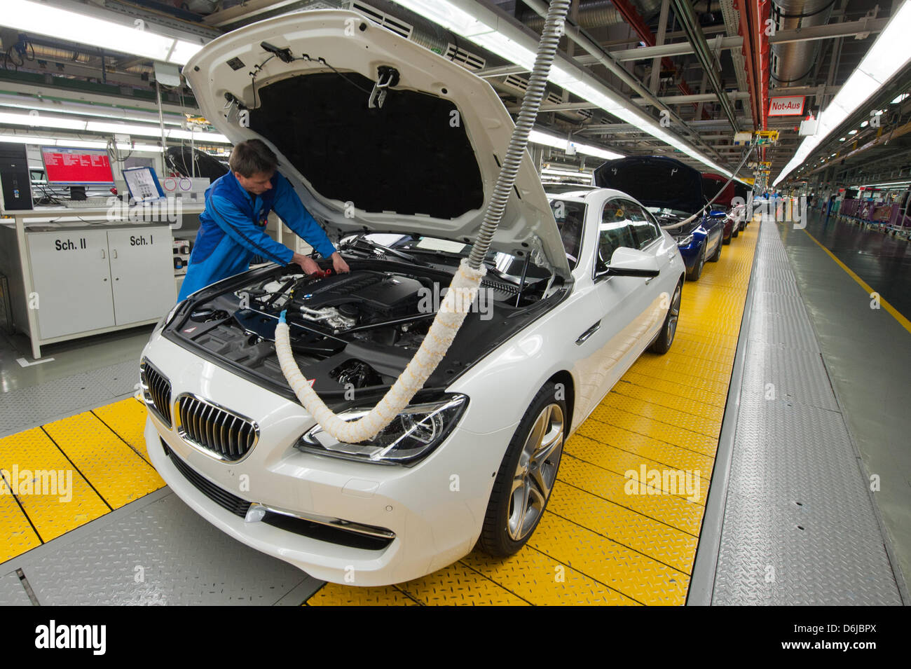 A BMW employee works on the engine of a BMW 6 inside the company's ...