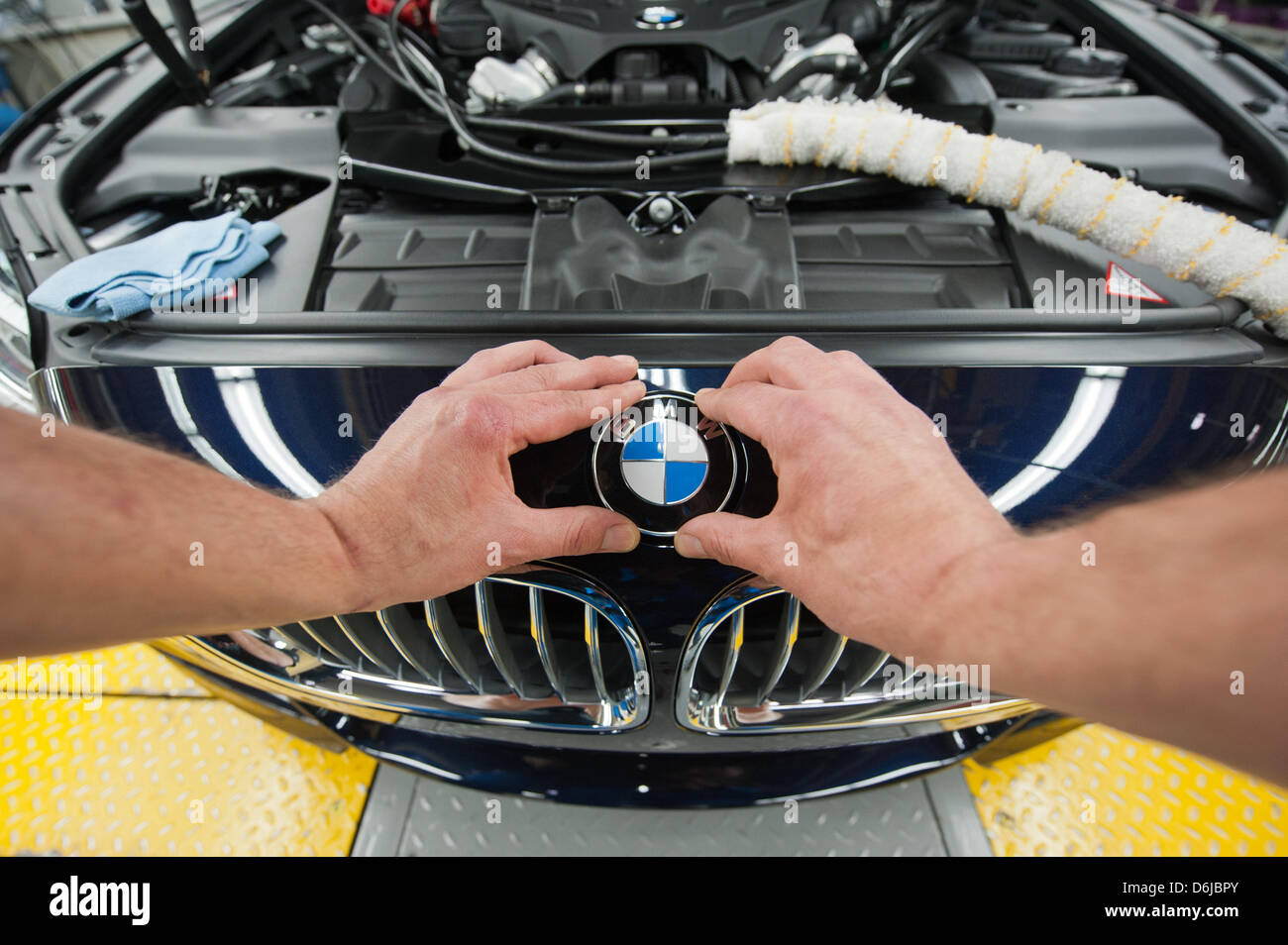 A BMW employee works on a BMW 6 inside the company's plant in ...