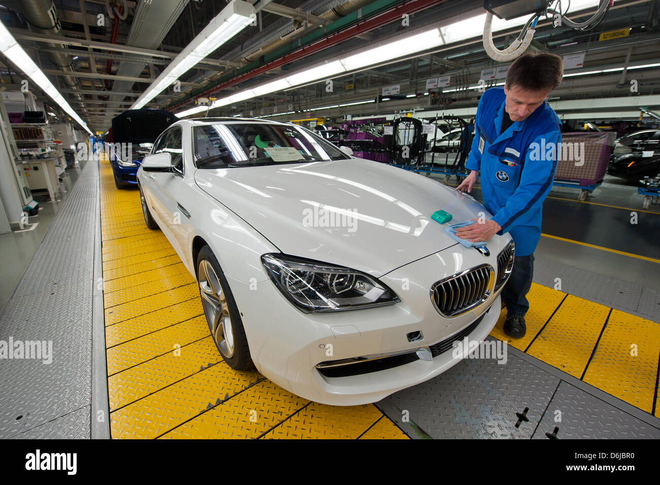 A BMW employee polishes a BMW 6 inside the company's plant in ...