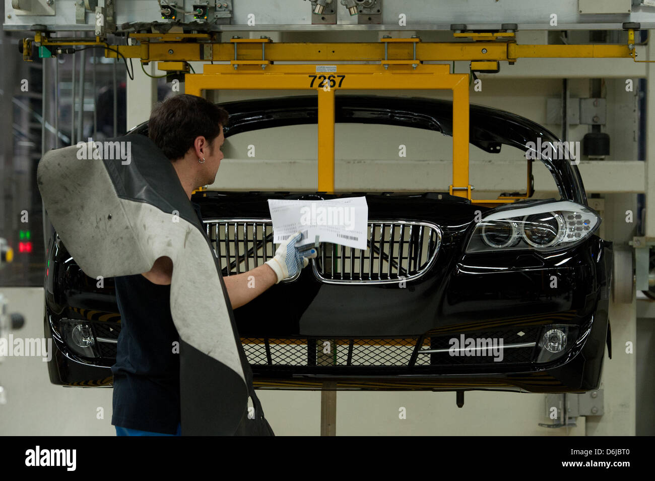 A BMW employee works on the front of a BMW 5 inside the company's plant ...