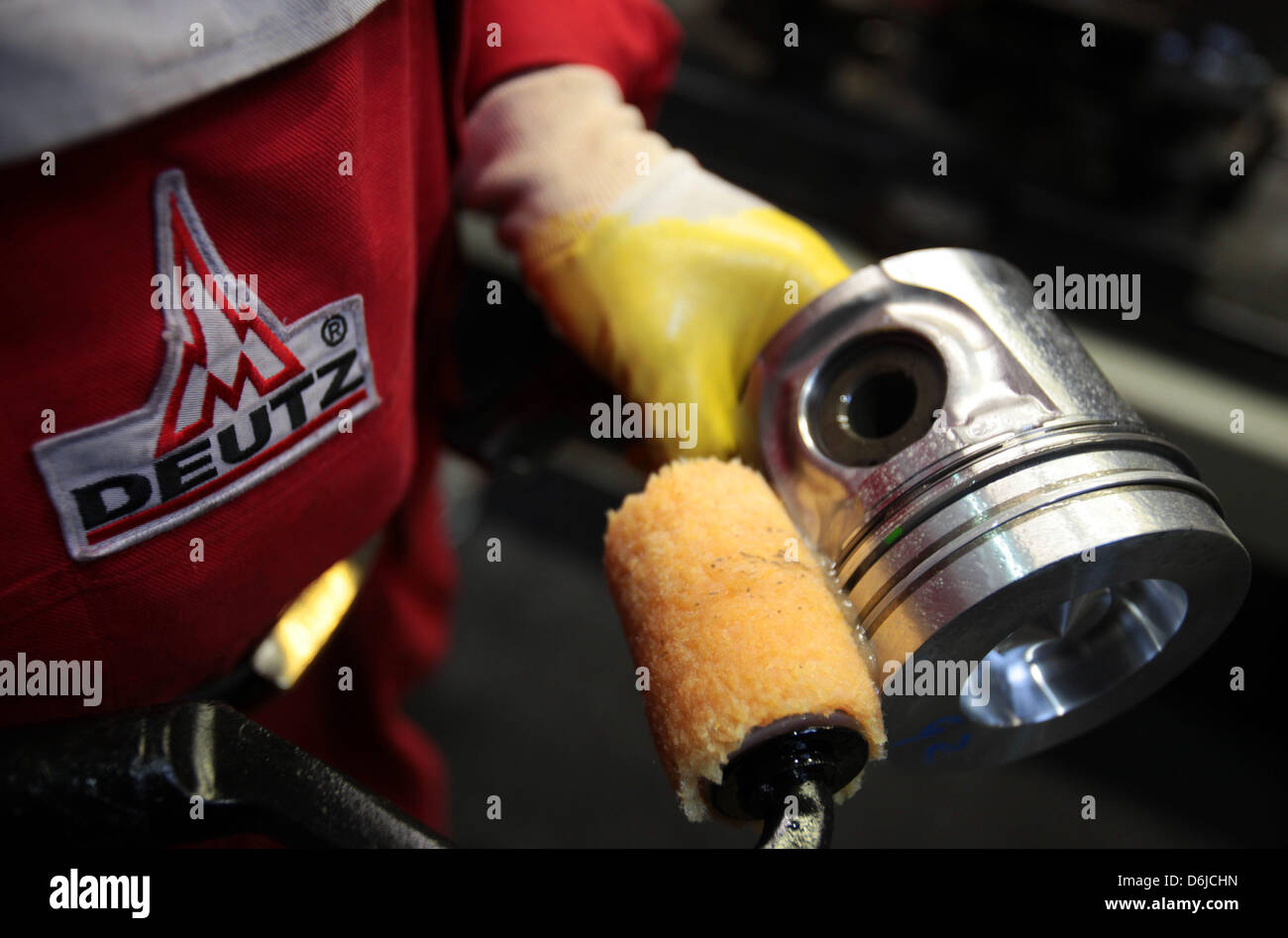 A member of staff of German engine manufacturer Deutz AG greases a ...