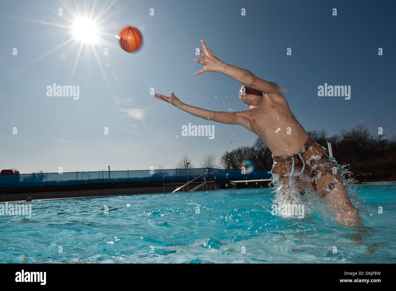 A boys jumps out of the water after a ball in a warm pool at Elyso ...
