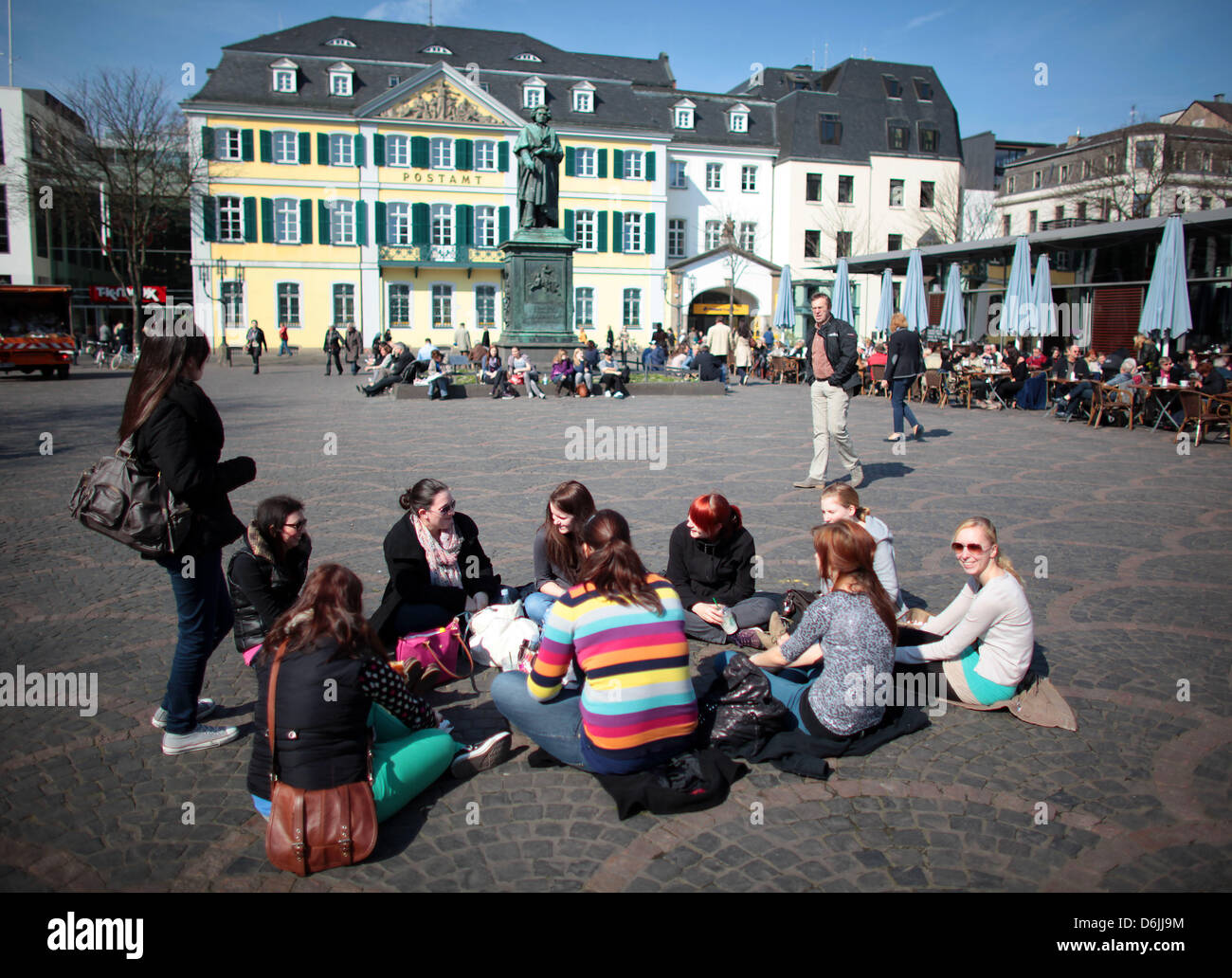 Students sit in the sun on Beethoven Square at lunchtime in Bonn ...