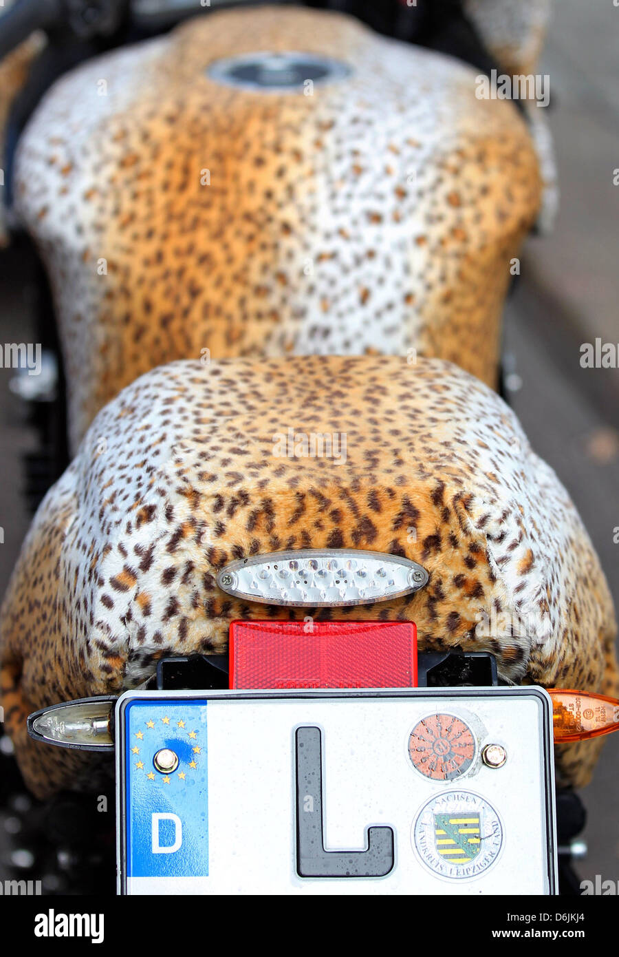 The seat of a motorcycle is covered with imitation in leopard skin is ...