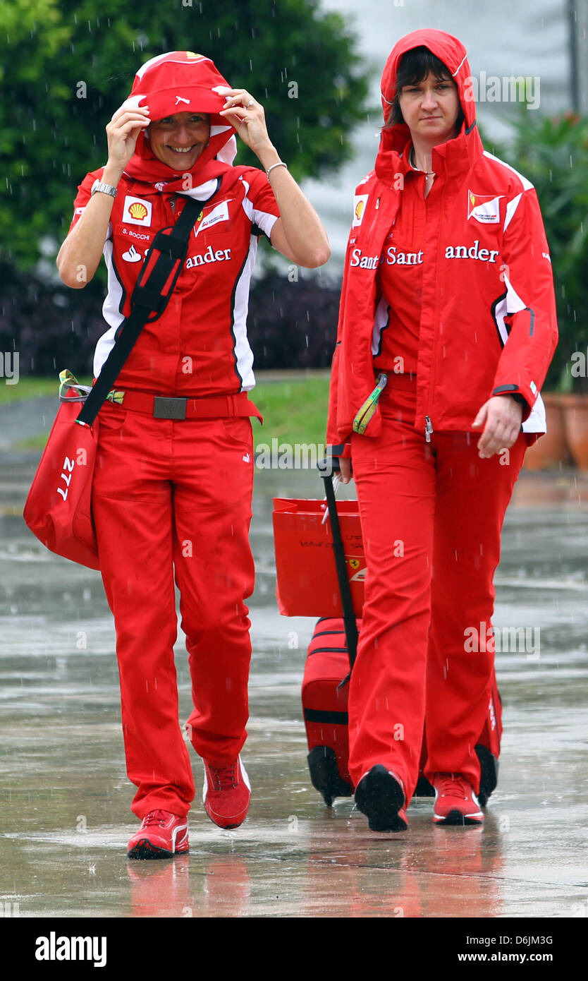 Team members of Ferrari arrive in the rain the paddock at the Sepang ...