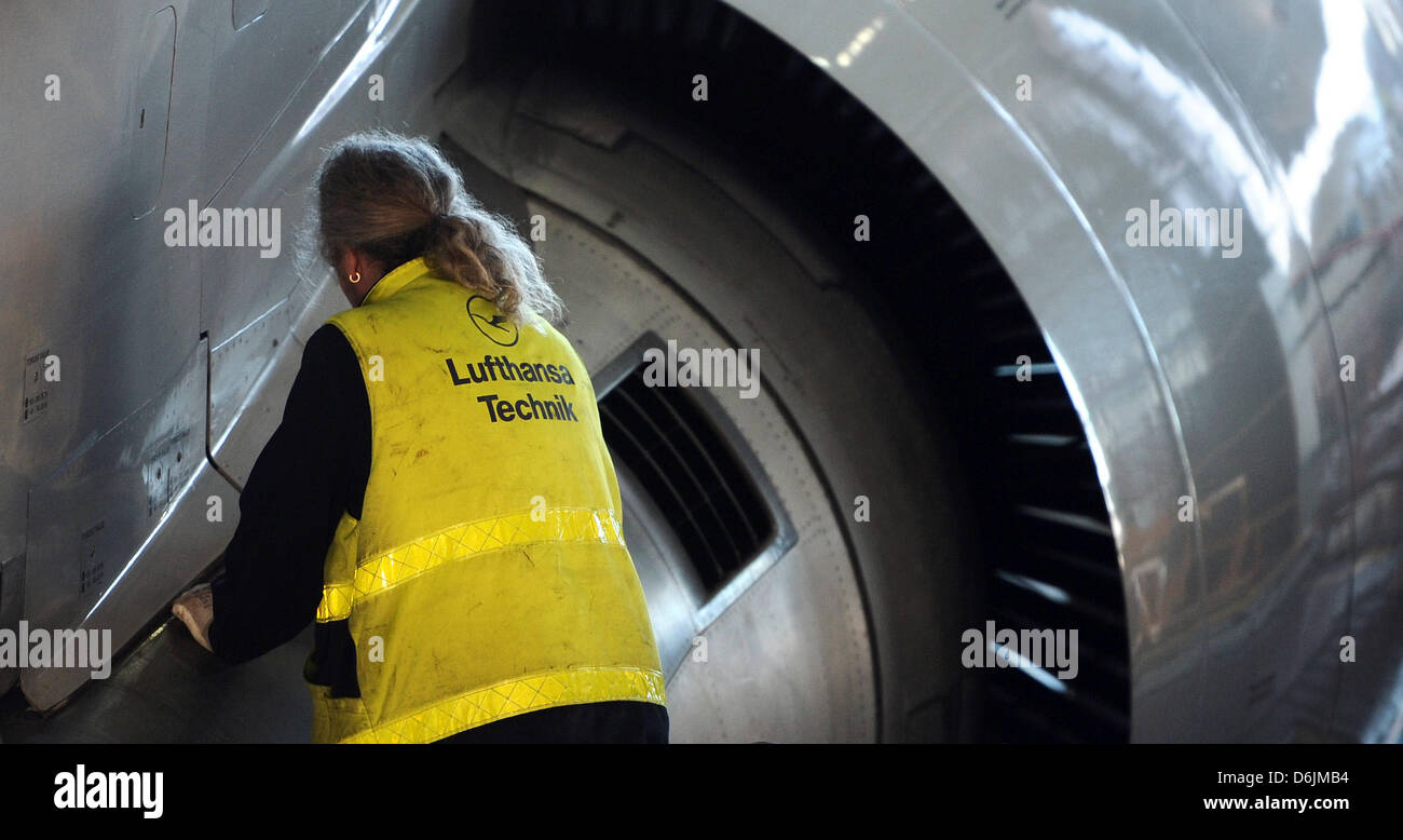 Technicians work on an engine of a Boeing 747-400 at a Jumbo ...