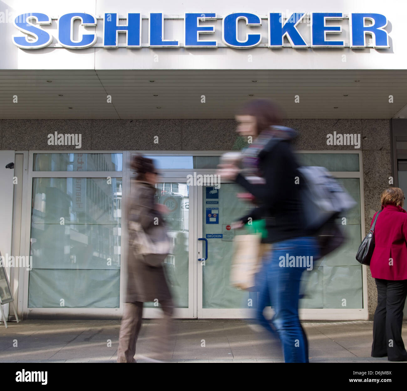 People walk past a branch of the drug store Schlecker that has been ...