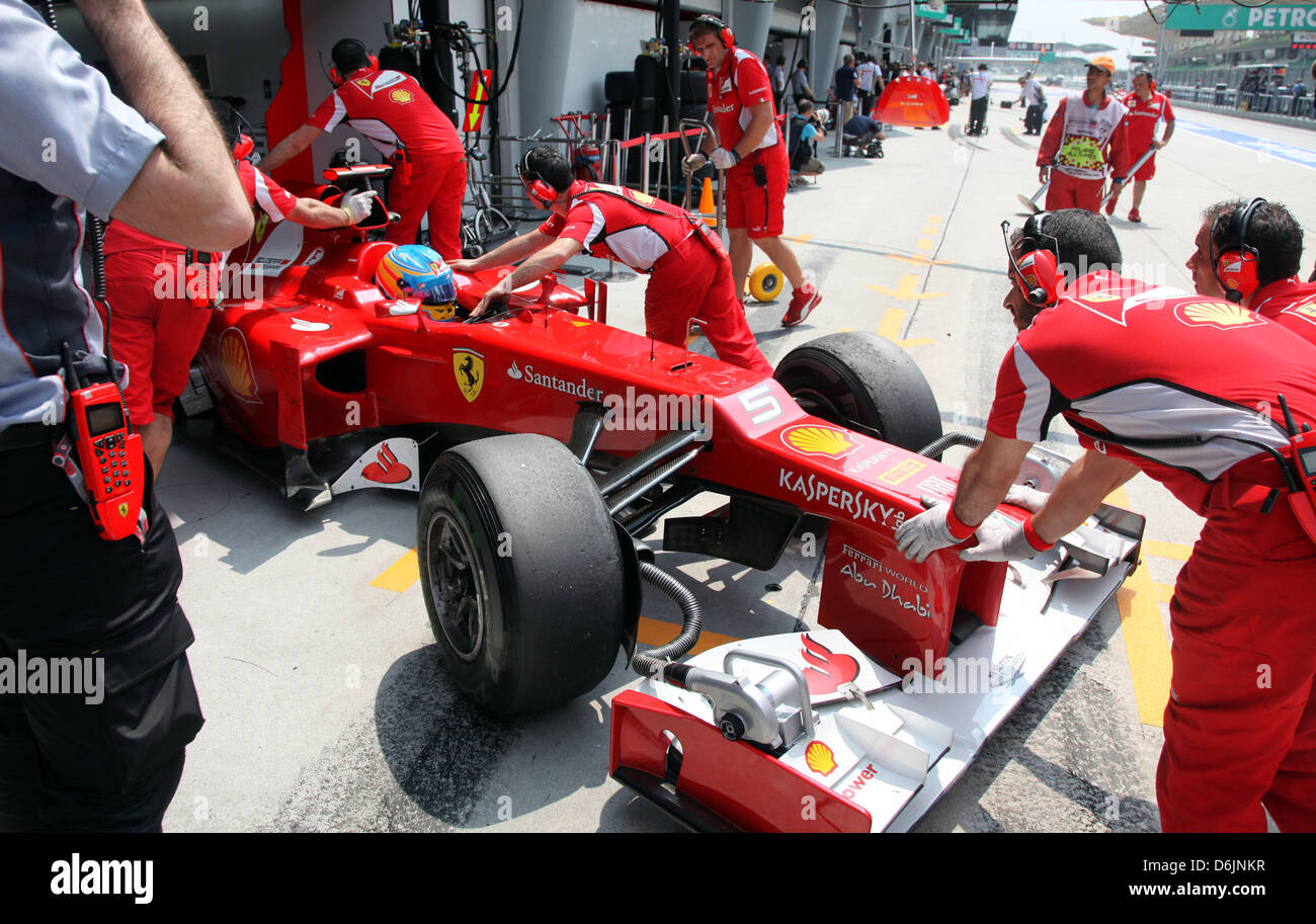 Mechanics push back the racing car of Spanish Formula One driver ...