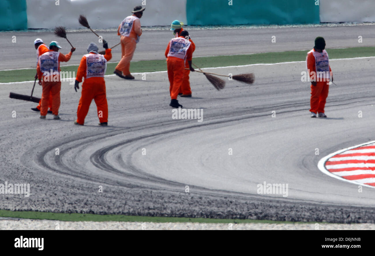 Marshals sweep the racetrack after the second practice session at the ...