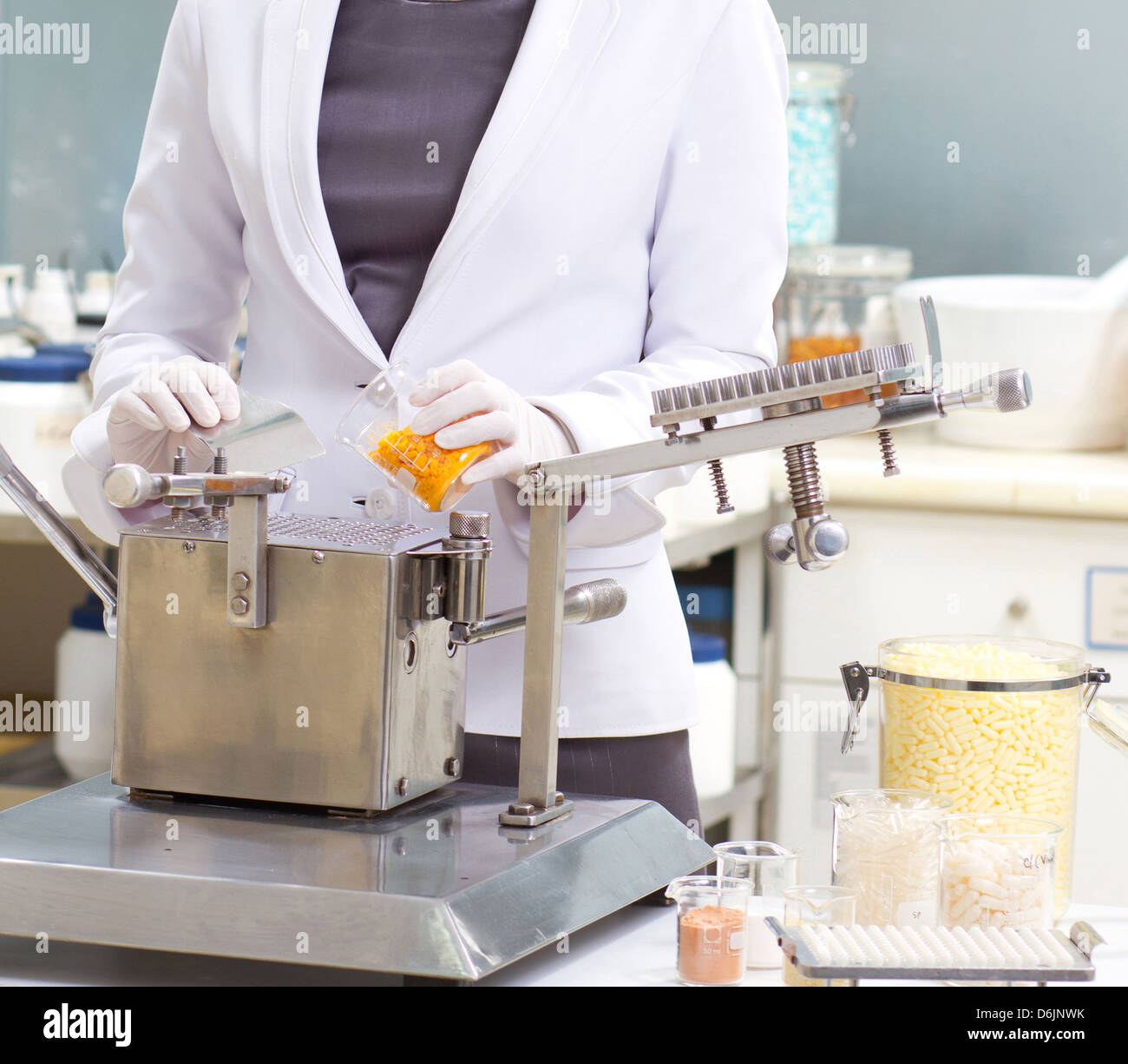 A pharmacist preparing medication with packaging capsule machine Stock ...