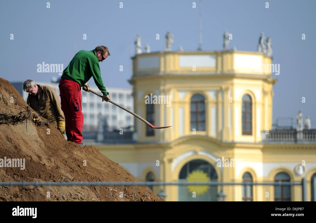 Workers stand on a mount of soil during the construction work for a ...
