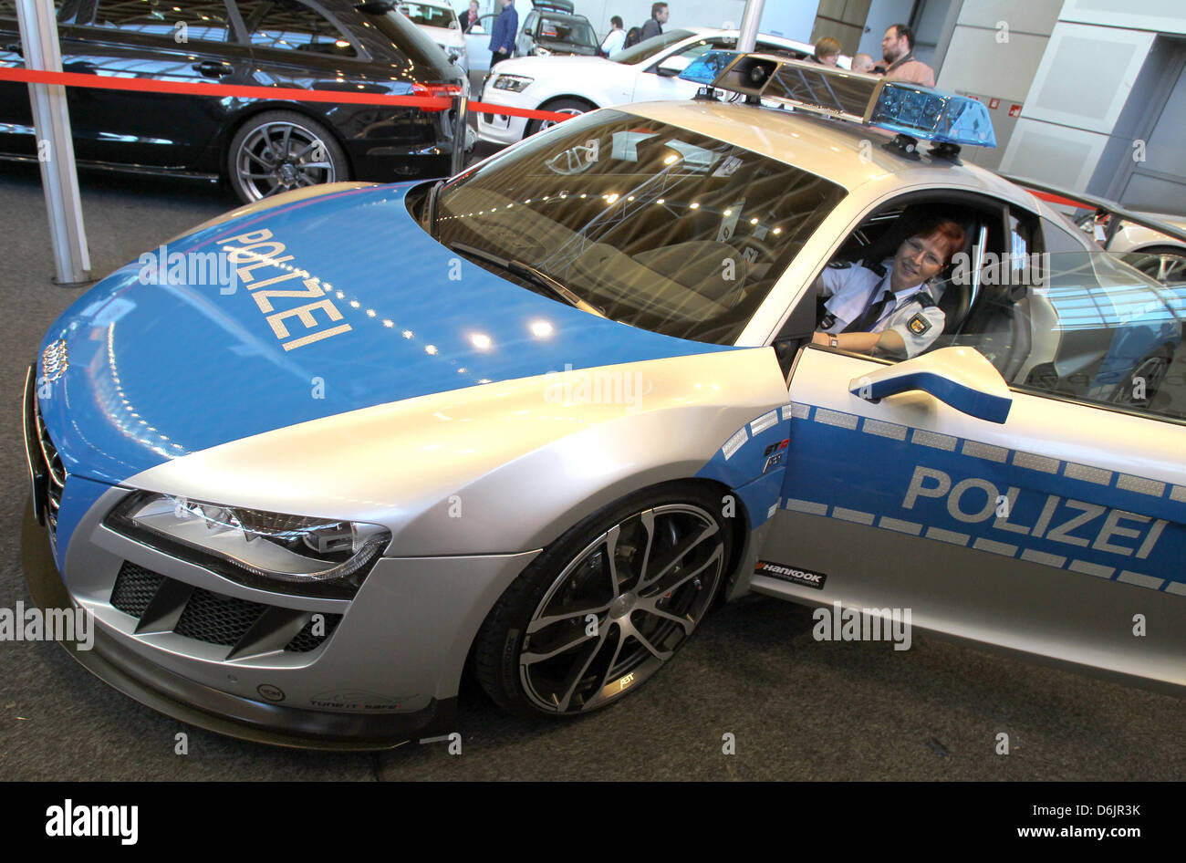 A policewoman views a tuned Audi ABT R8 GTR at car show Auto Trend 2012 ...