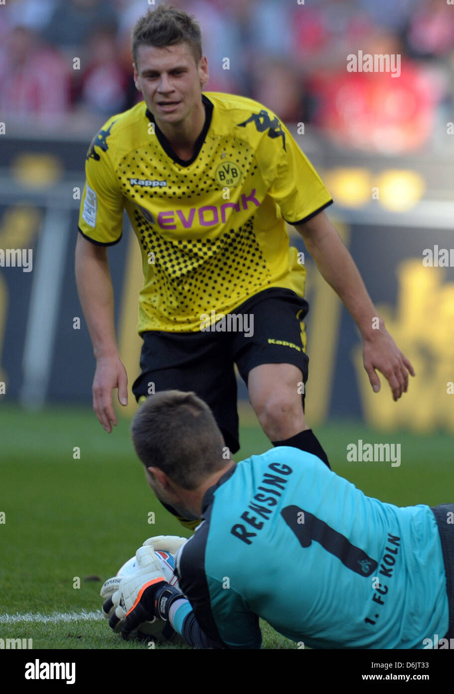 Cologne's goalkeeper Michael Rensing (below) saves the ball in front of ...