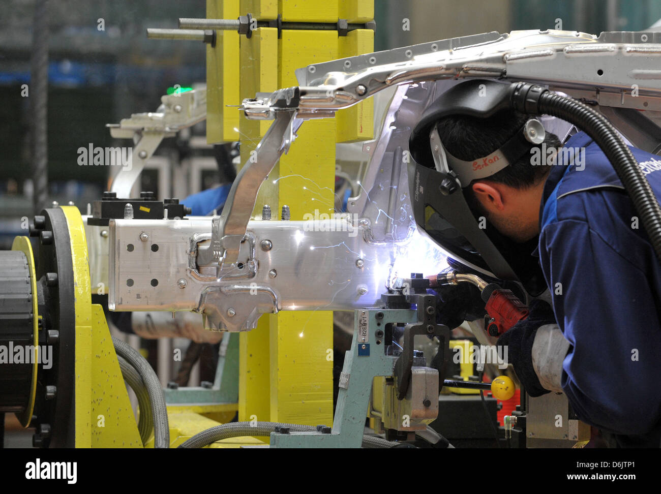 A mechanic works on the body of the new Mercedes-Benz SL sports car at ...