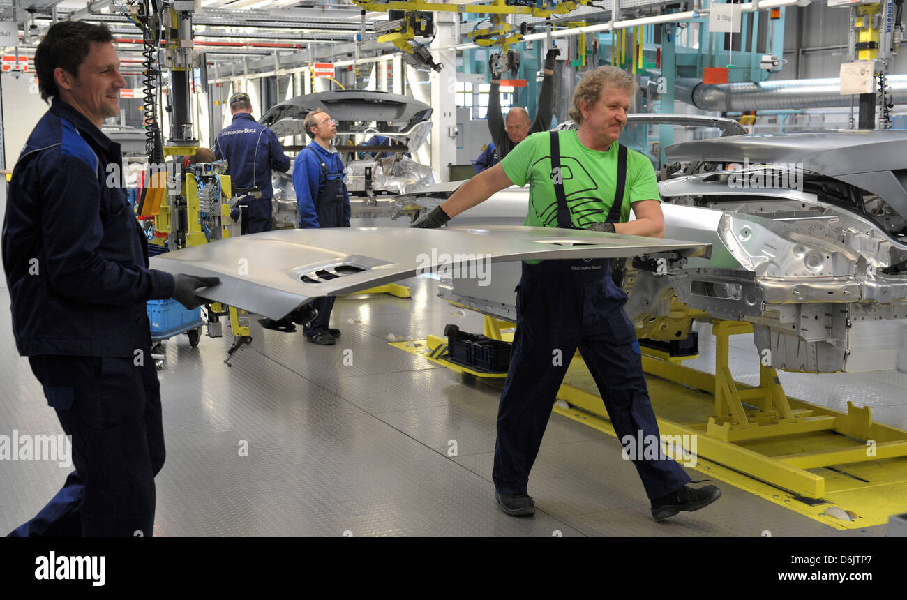 Mechanics carry a hood of the new Mercedes-Benz SL sports car at the ...
