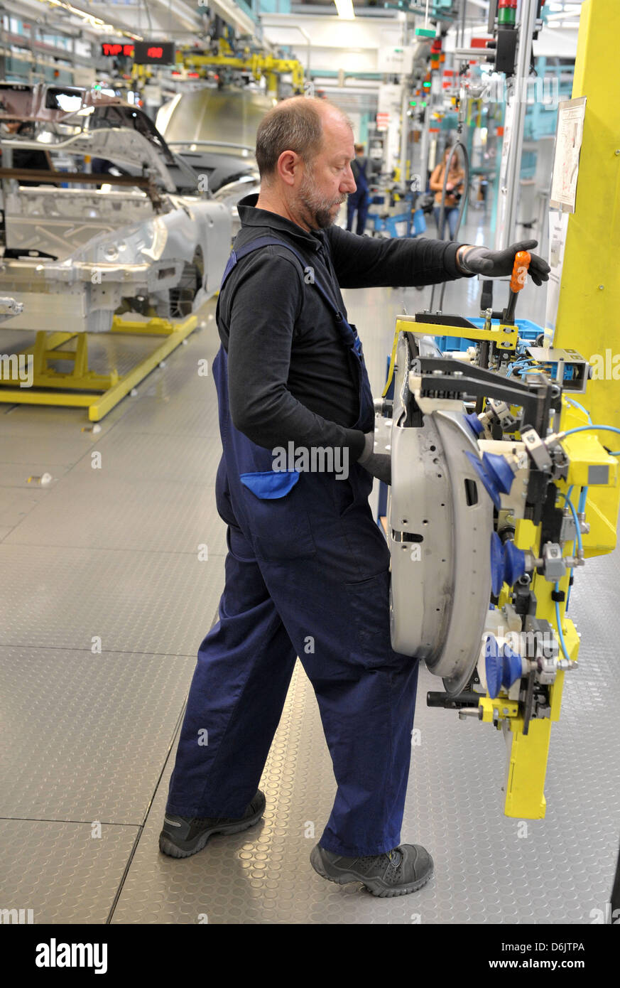 A mechanic works on the body of the new Mercedes-Benz SL sports car at ...
