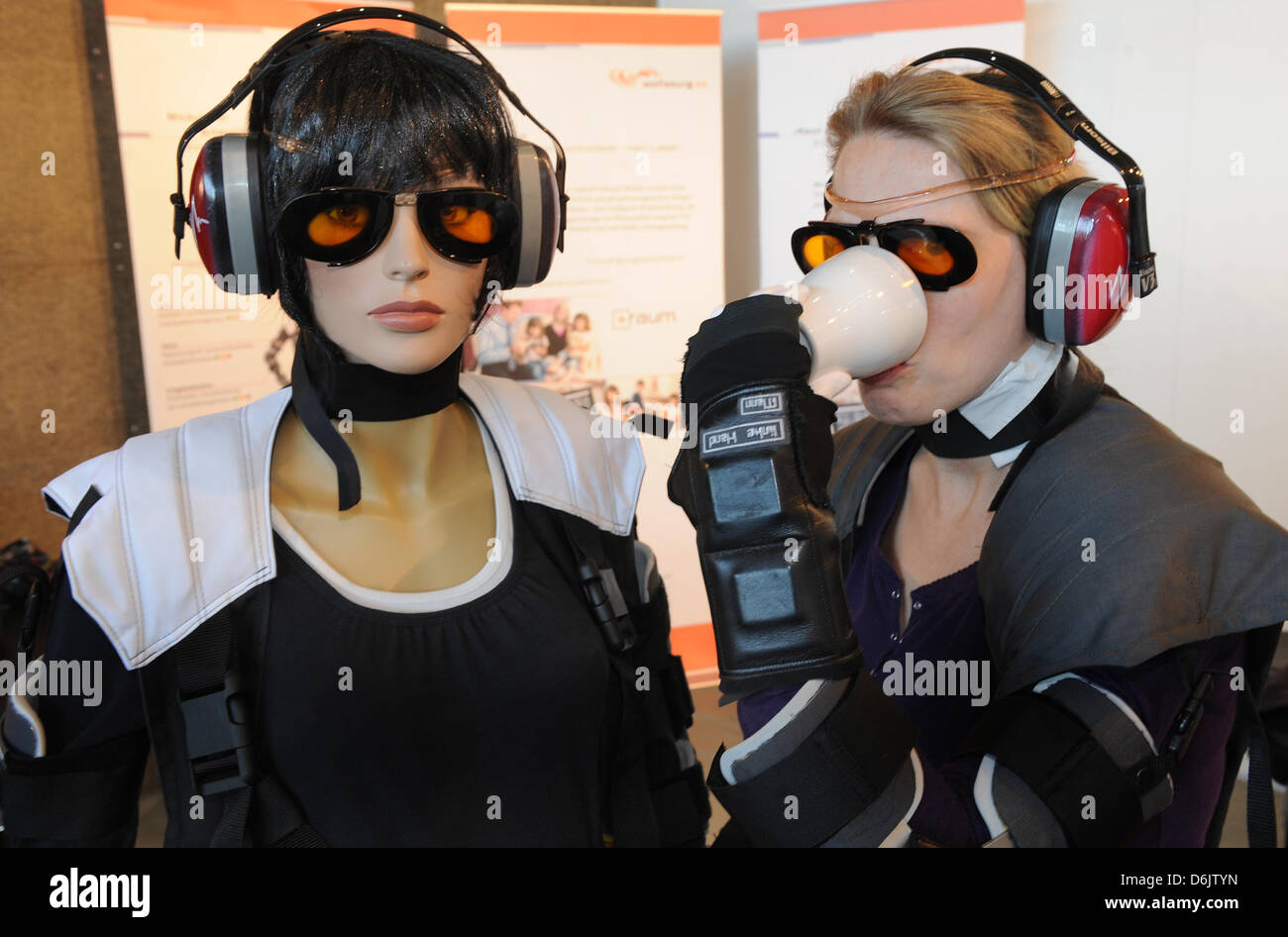 A fair staff member (L) poses in a so-called Modular Age Simulation ...