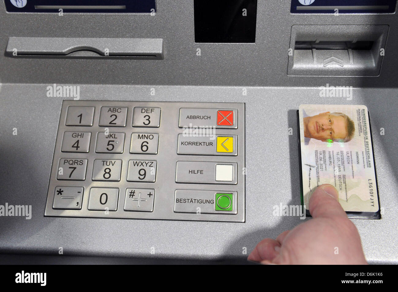 A man uses his new identity card at an automated teller machine at the ...