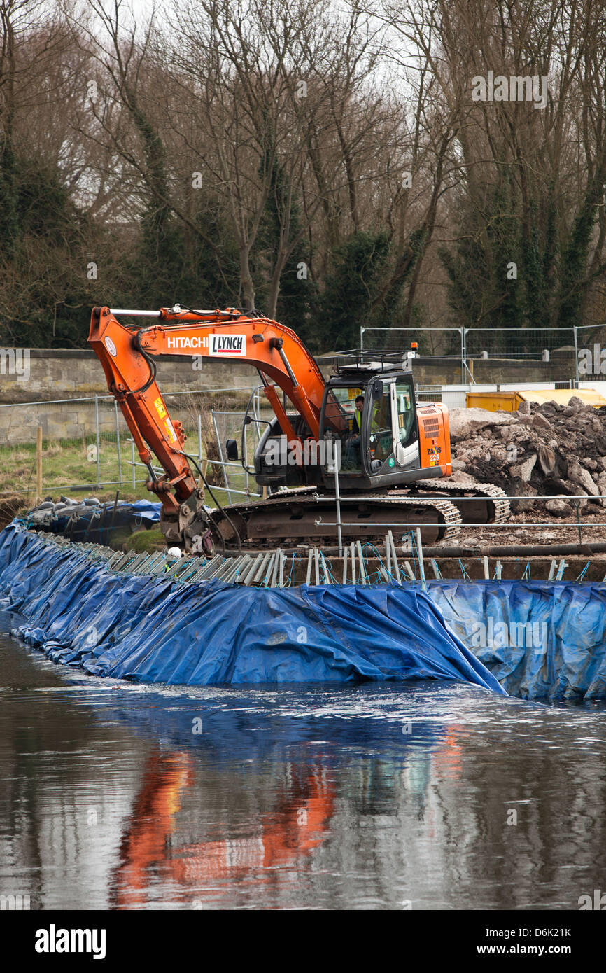 A mechanical excavator with a hydraulic hammer attachment at work on a ...