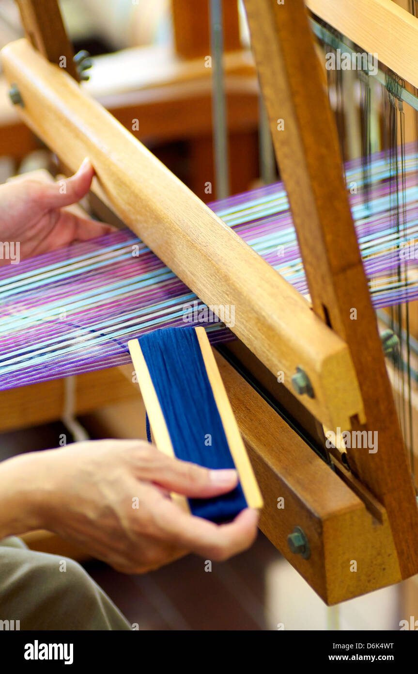 Woman working on a traditional, manual loom, weaving Stock Photo - Alamy