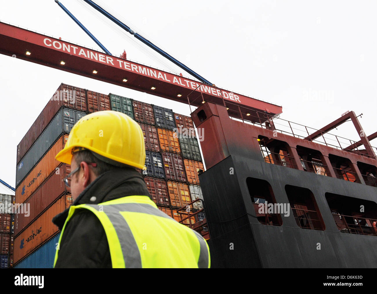 Two employees of Hamburger Hafen und Logistik AG (HHLA) stand next to a ...