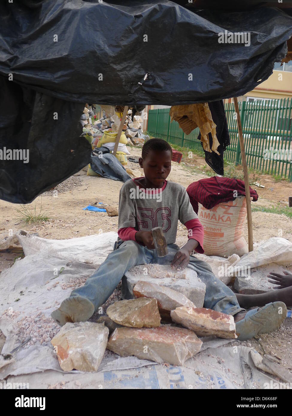 10 year old Phresa Kawanga beating a heavy stone to bits with hammer ...