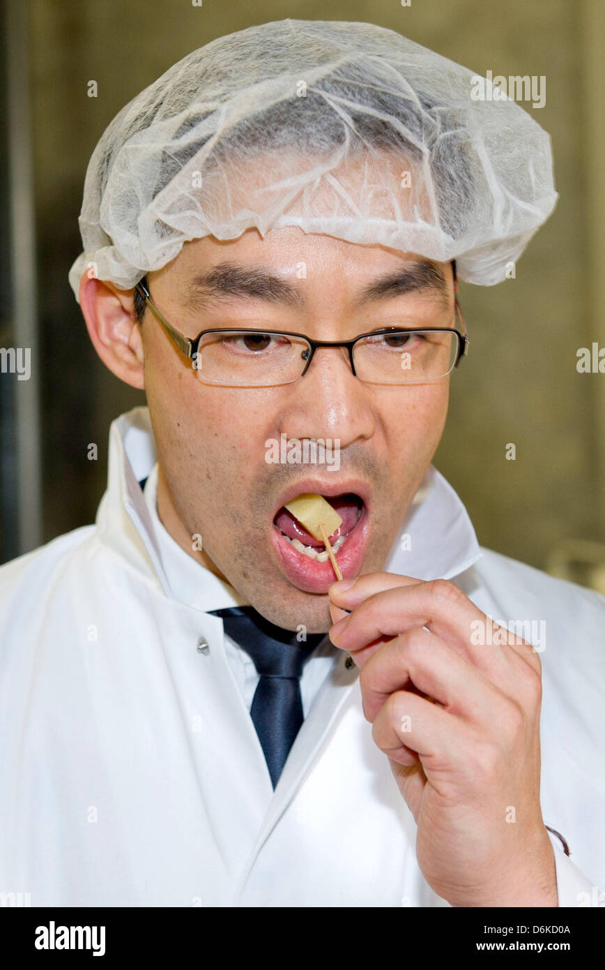 German Minister of Economics Philipp Roesler (FDP) samples a piece of ...
