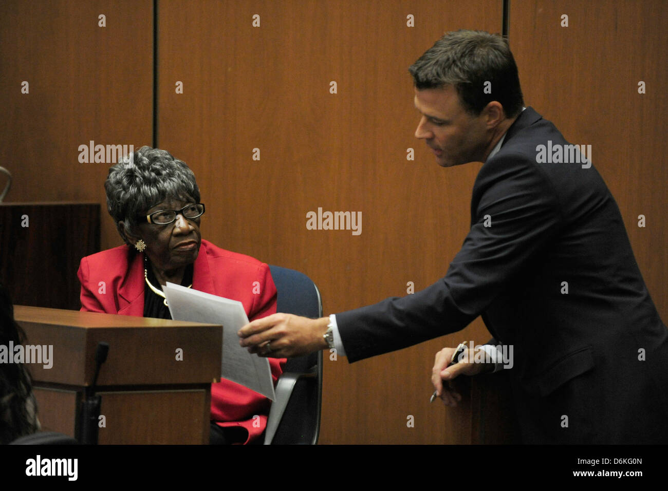 Deputy District Attorney David Walgren (R) hands Ruby Mosley (L ...
