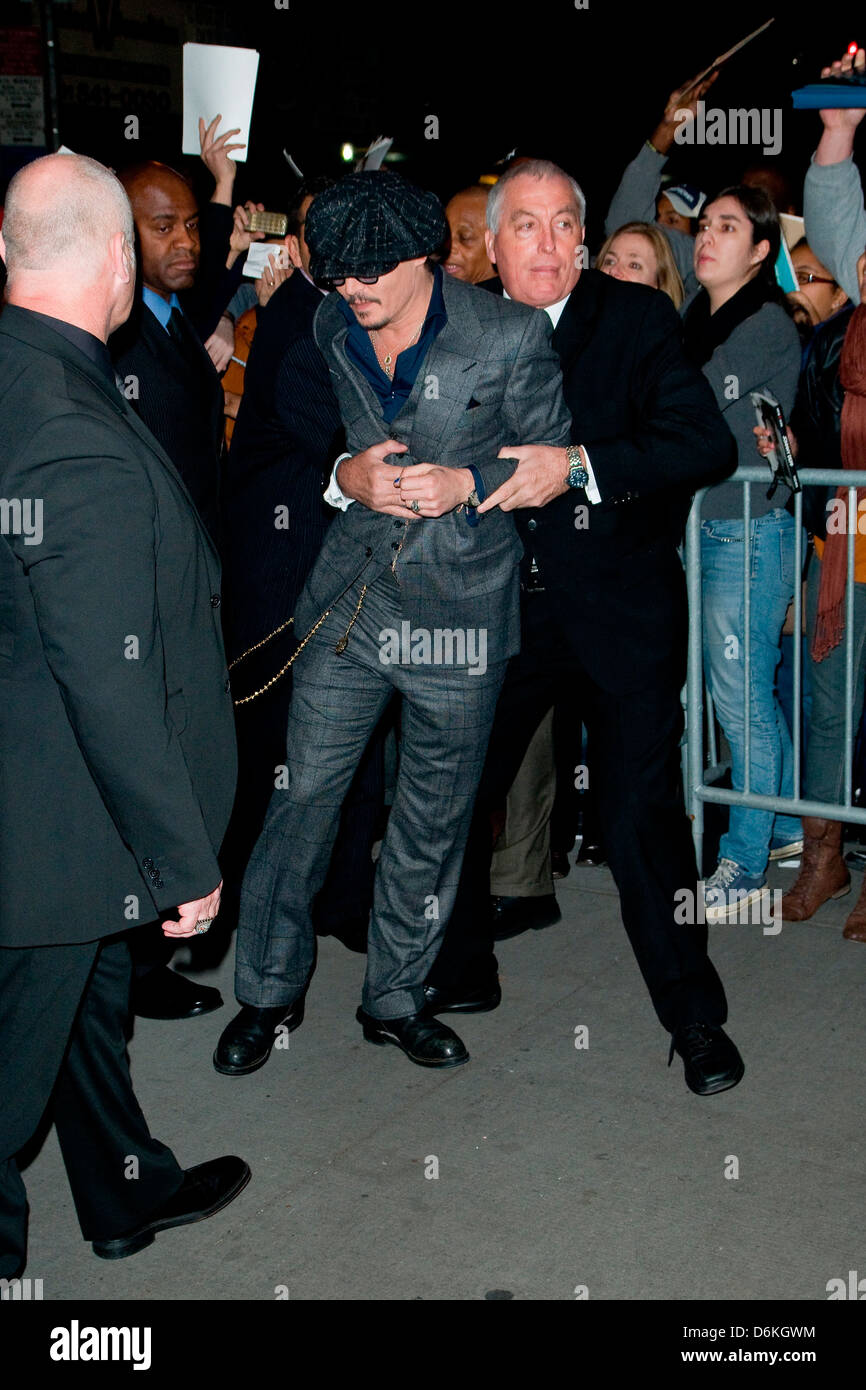 Johnny Depp is pulled away by his security guard while signing ...
