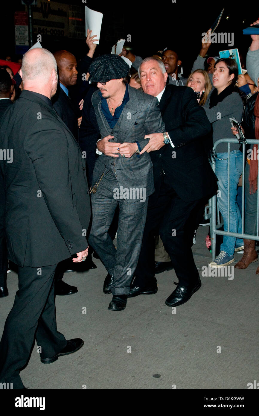 Johnny Depp is pulled away by his security guard while signing ...