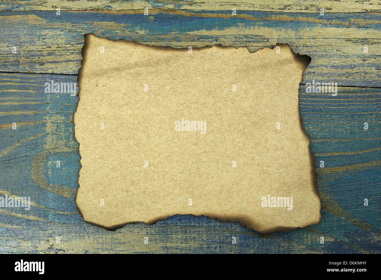 Burnt paper on blue old wood background Stock Photo - Alamy
