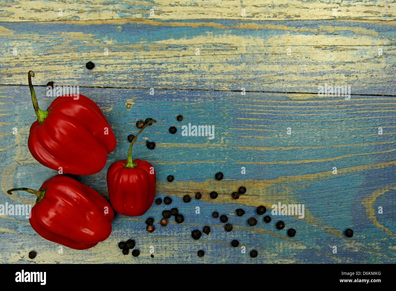 Composition of three chili peppers on wood background Stock Photo - Alamy