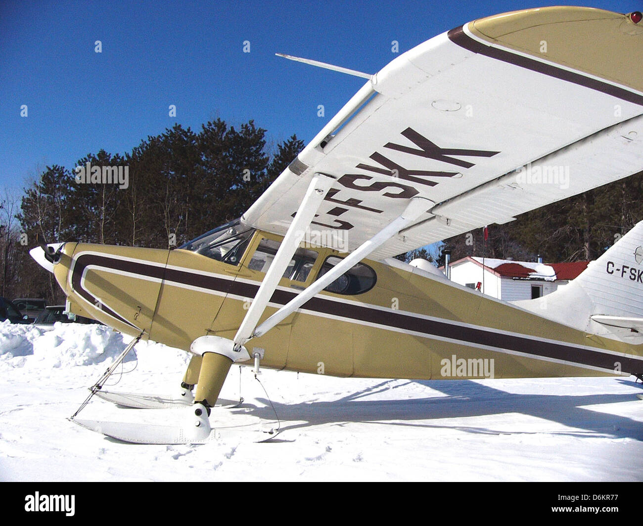 This photo shows a Stinson 108-3, a small American aircraft, in a clear ...