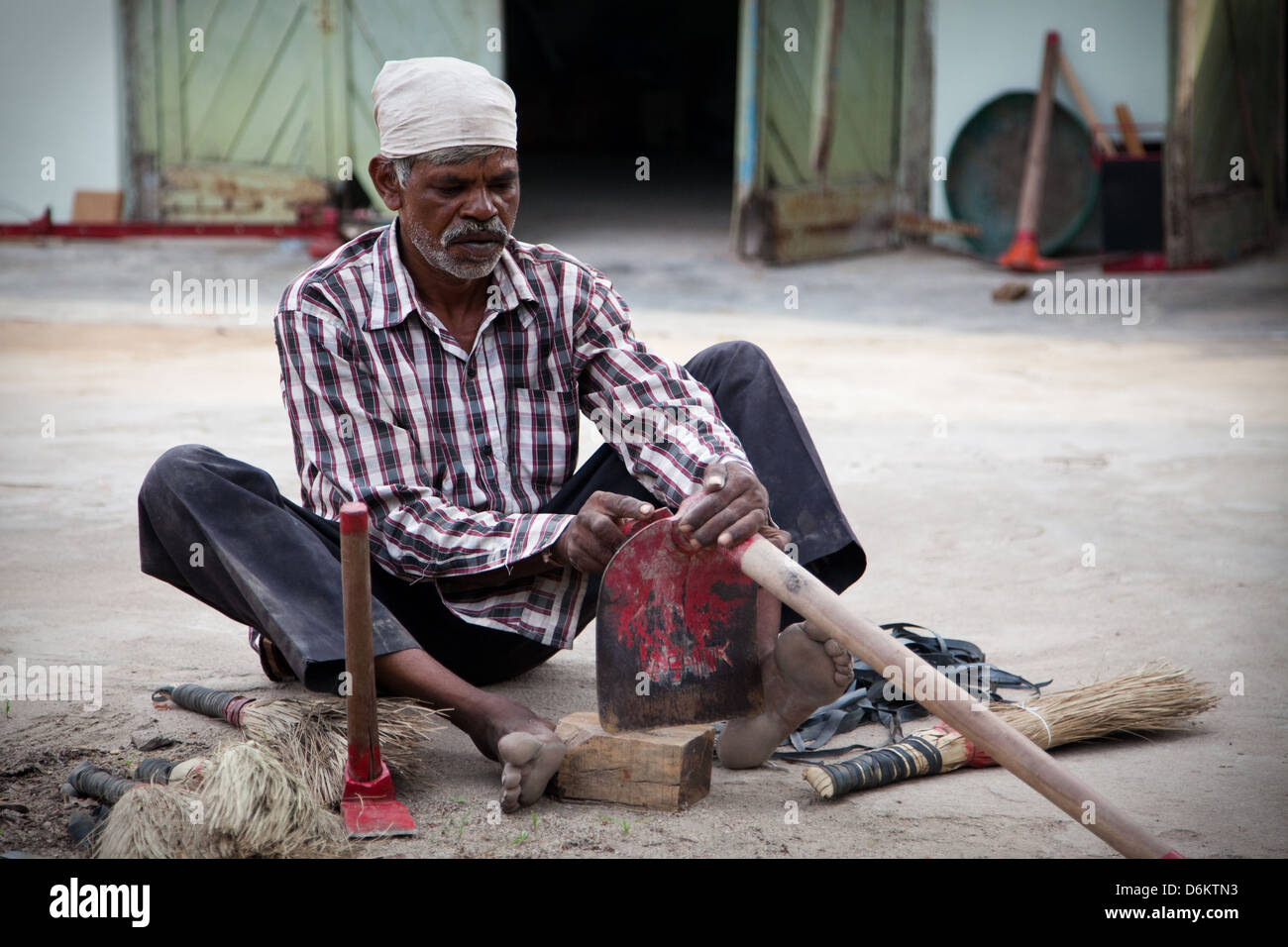 A construction worker cleans tools on a building site in Balasinor ...
